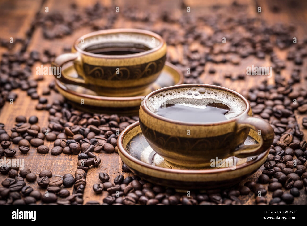 Two cups of coffee on wooden table Stock Photo - Alamy