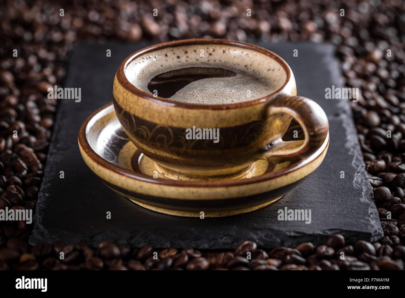 Cup of coffee on black slate. Coffee beans background Stock Photo - Alamy