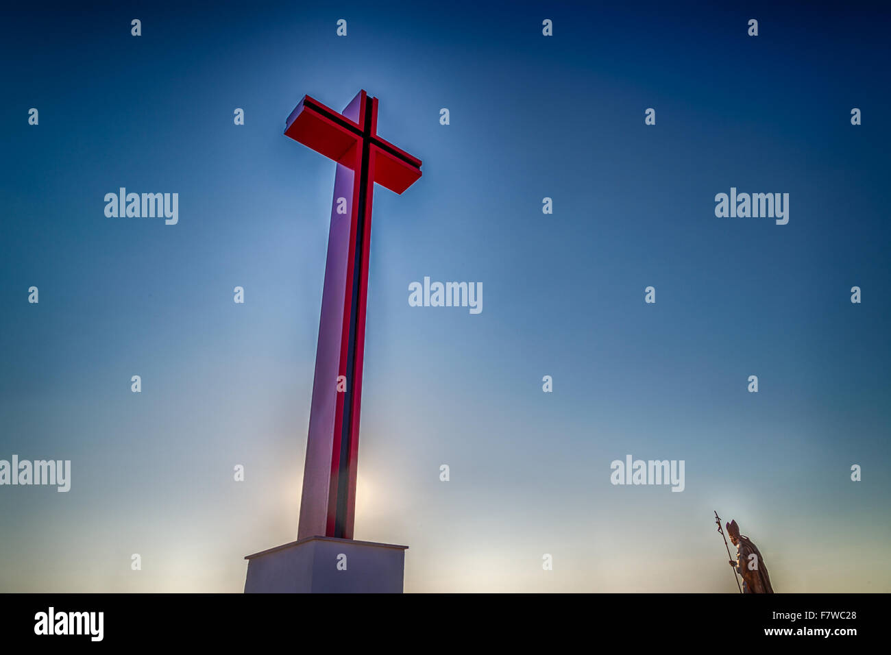 Giant red Cross and bronze statue of Holy Pope with Crucifix seen from ...