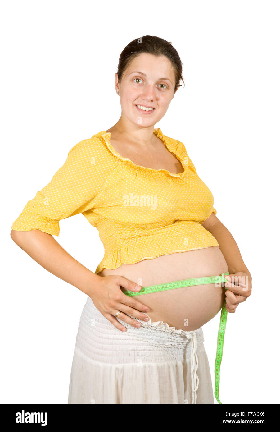 Happy pregnant woman measuring belly over white background Stock Photo ...