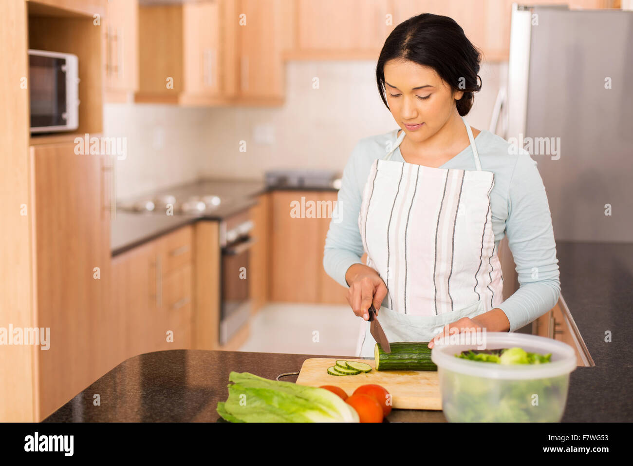 pretty Indian woman preparing dinner in home kitchen Stock Photo - Alamy