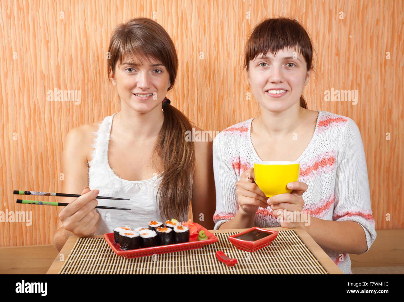 Two women eating sushi rolls Stock Photo - Alamy