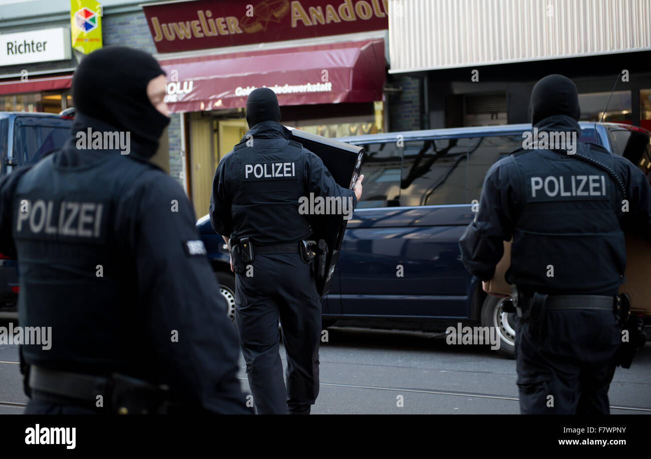 Duesseldorf, Germany. 03rd Dec, 2015. Masked police officers carry a ...