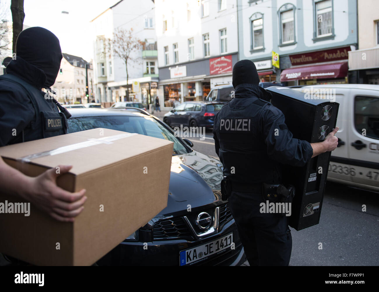Duesseldorf, Germany. 03rd Dec, 2015. Masked police officers carry a ...