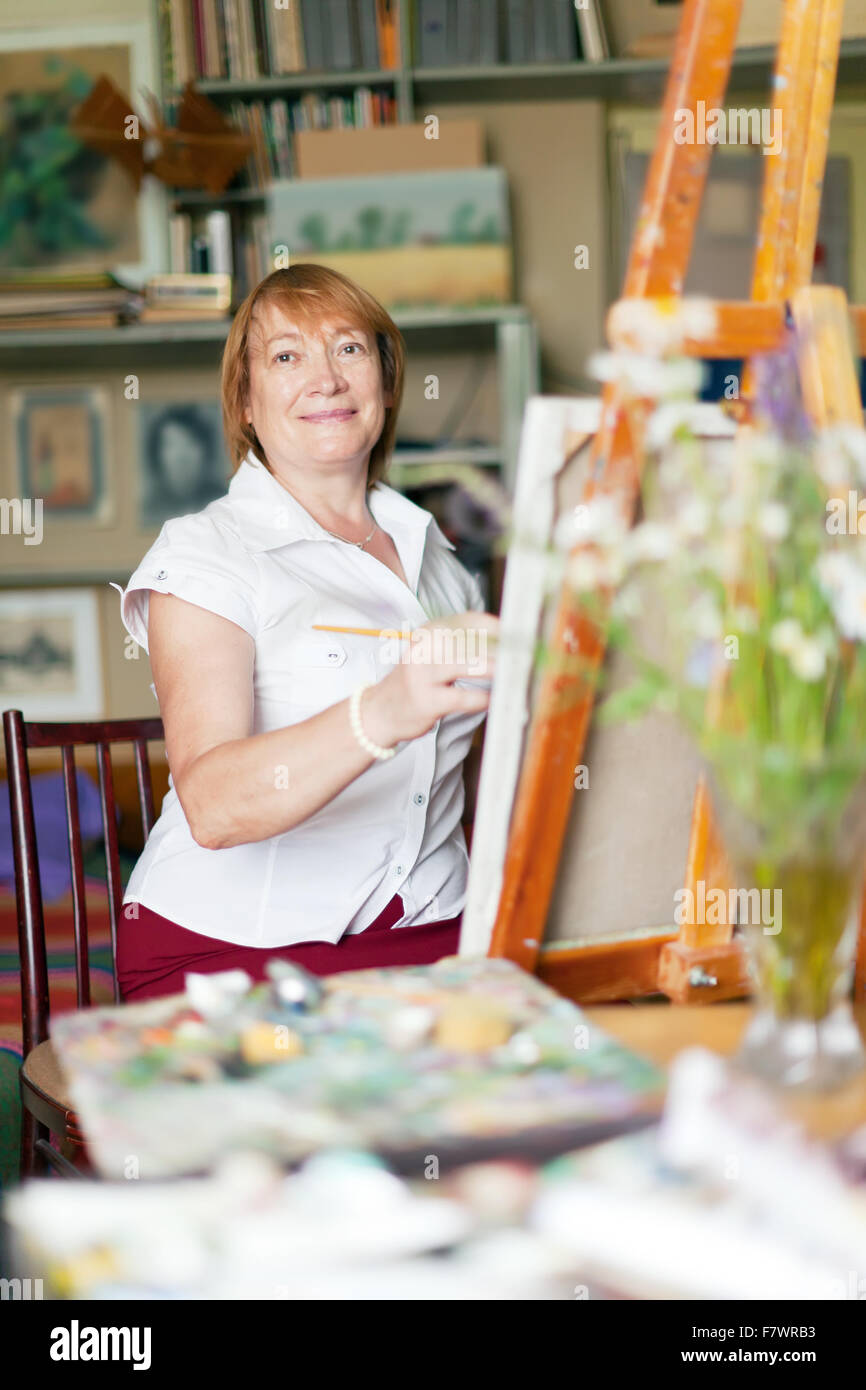 Female artist paints a picture on canvas with oil paints Stock Photo ...