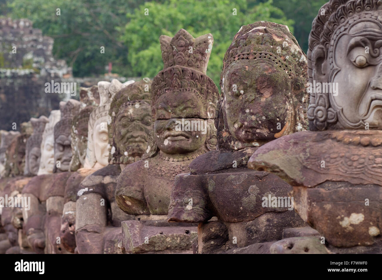 Stone carved faces on the bridge at the south gate of Angkor Thom ...