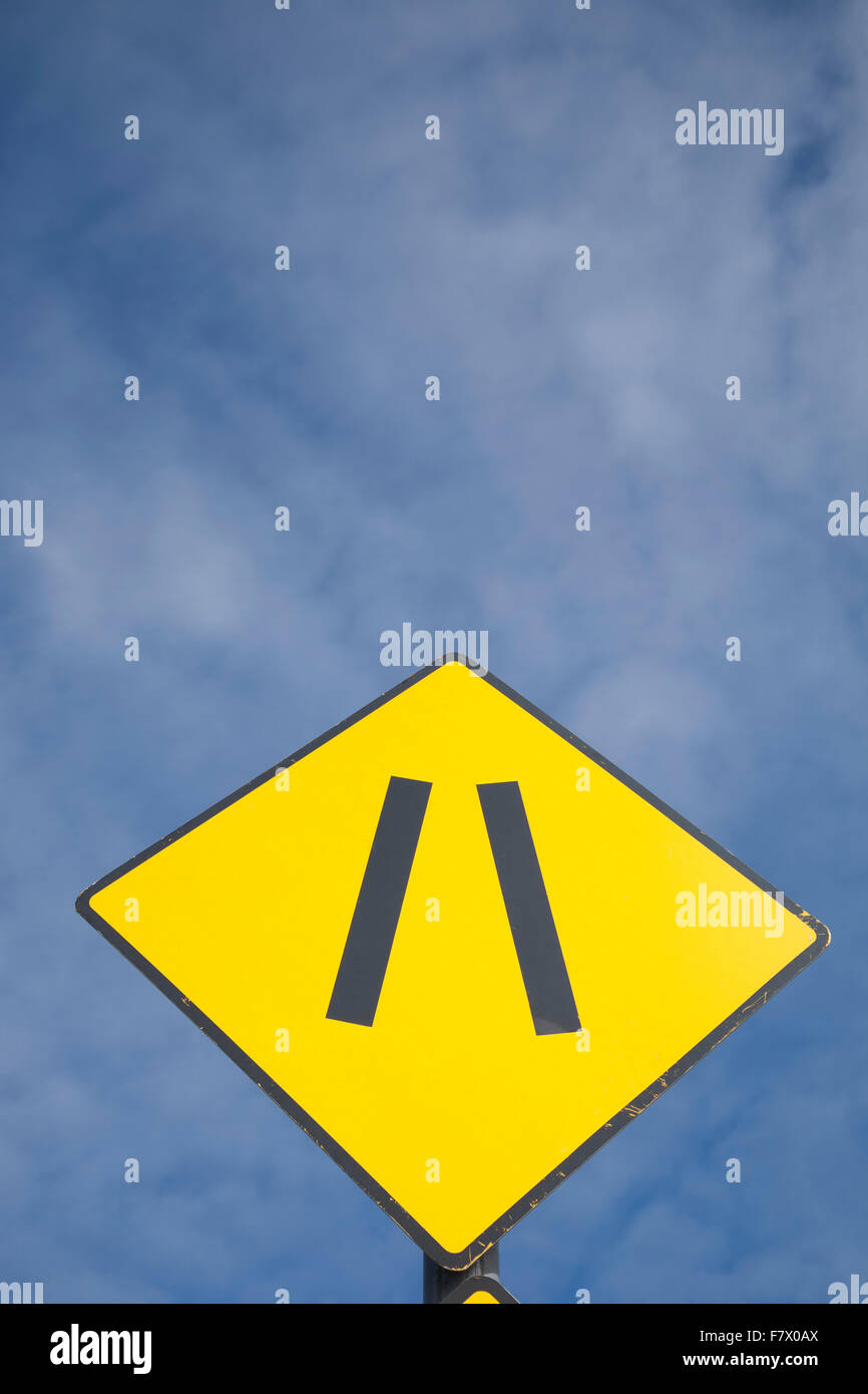 Road Narrowing Sign against Blue Sky Background Stock Photo - Alamy