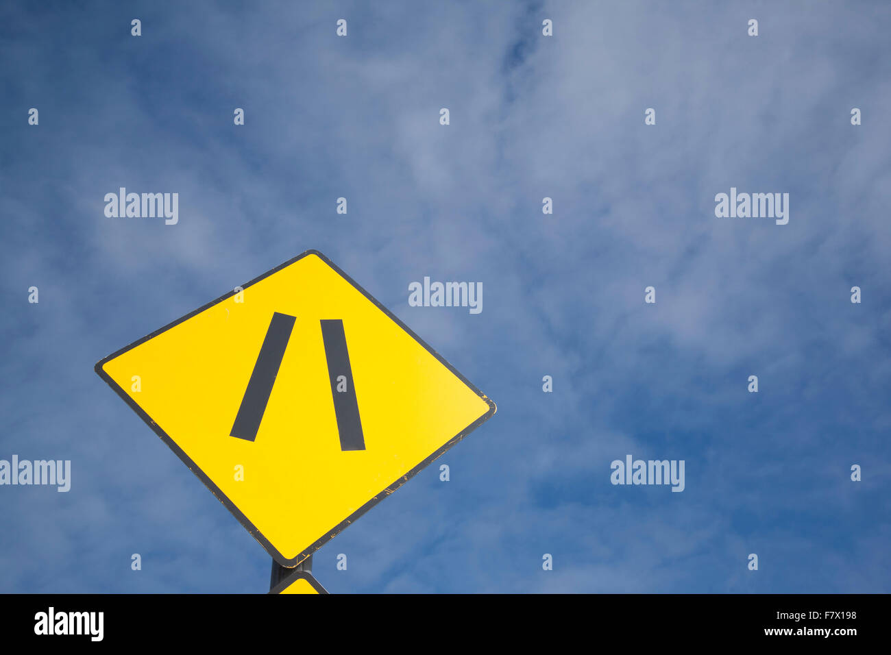 Road Narrowing Sign against Blue Sky Background Stock Photo - Alamy