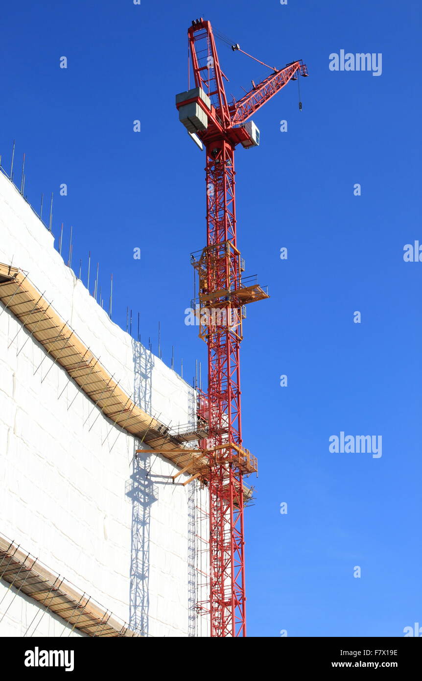 Red crane by the construction site of a skyscraper Stock Photo - Alamy