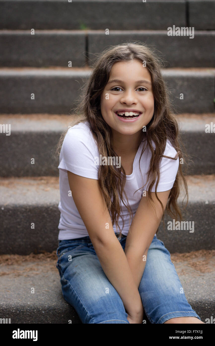 Portrait of a girl sitting on stairs outside Stock Photo - Alamy