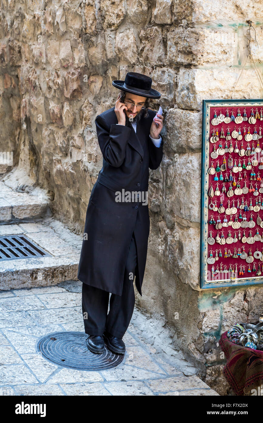 An Orthodox Jewish young man on a cell phone in the Jewish Quarter in ...