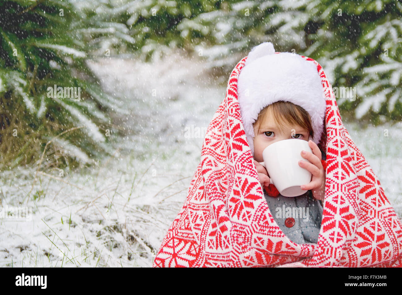 Girl drinking hot cocoa in the snow Stock Photo - Alamy