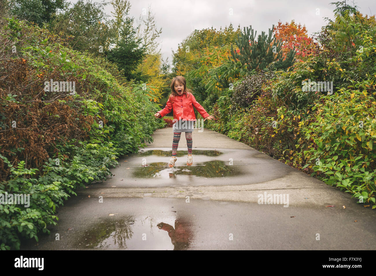Girl jumping in a puddle Stock Photo - Alamy