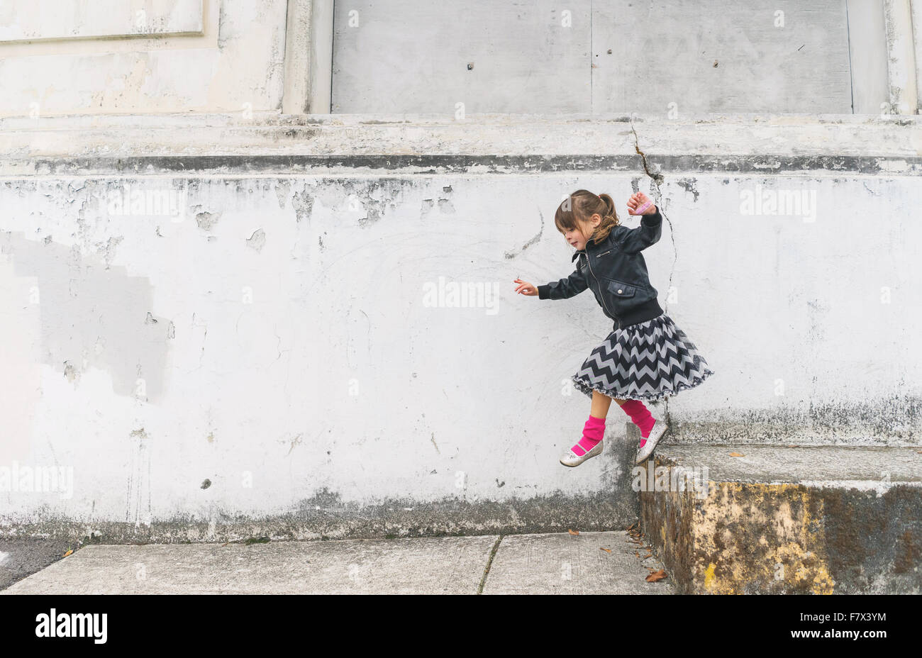 Girl jumping off a step Stock Photo - Alamy