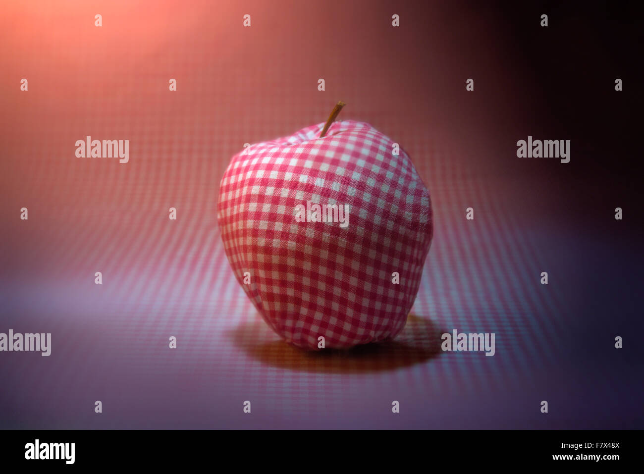 Apple covered in checkered material on checkered material background ...