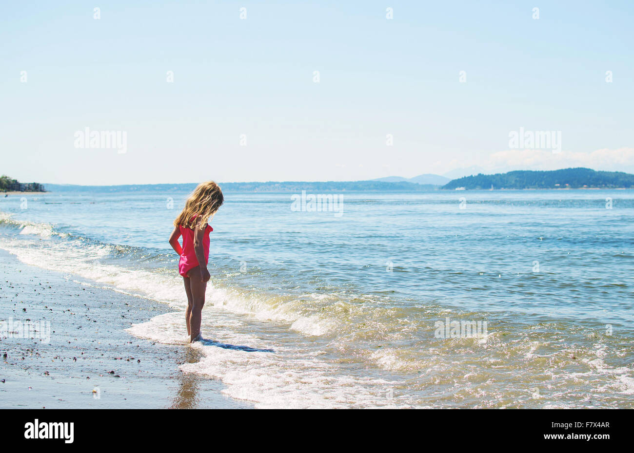 Girl in swimming costume standing by sea Stock Photo - Alamy