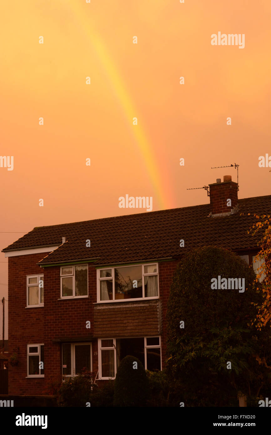 Rainbow and storm clouds lit orange by sunset Stock Photo - Alamy