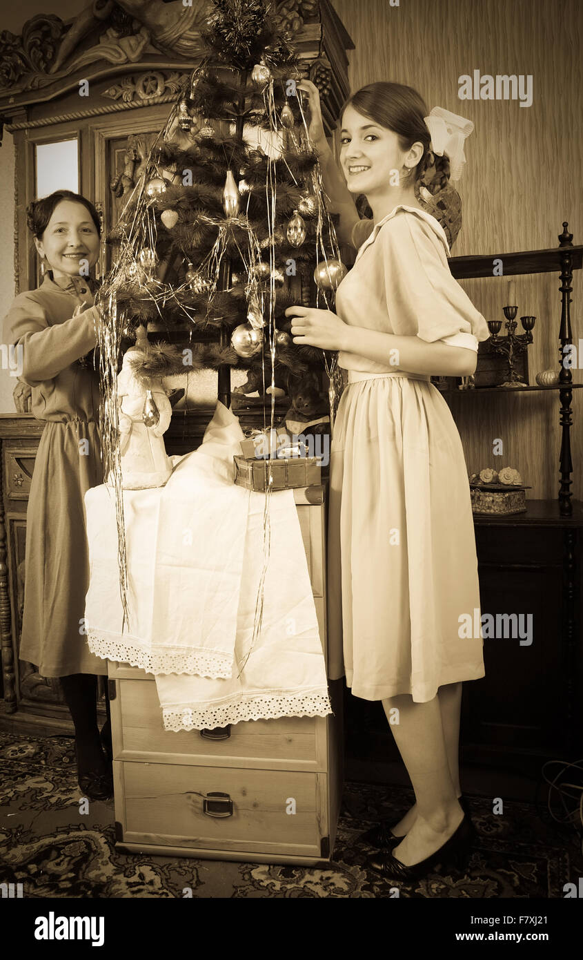 Vintage photo of Two women decorating Christmas tree at home Stock ...