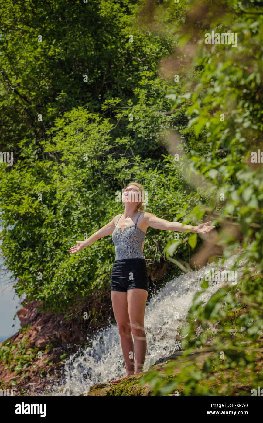 Young Woman doing Yoga Position in Front of the Ocean Near a Waterfall ...
