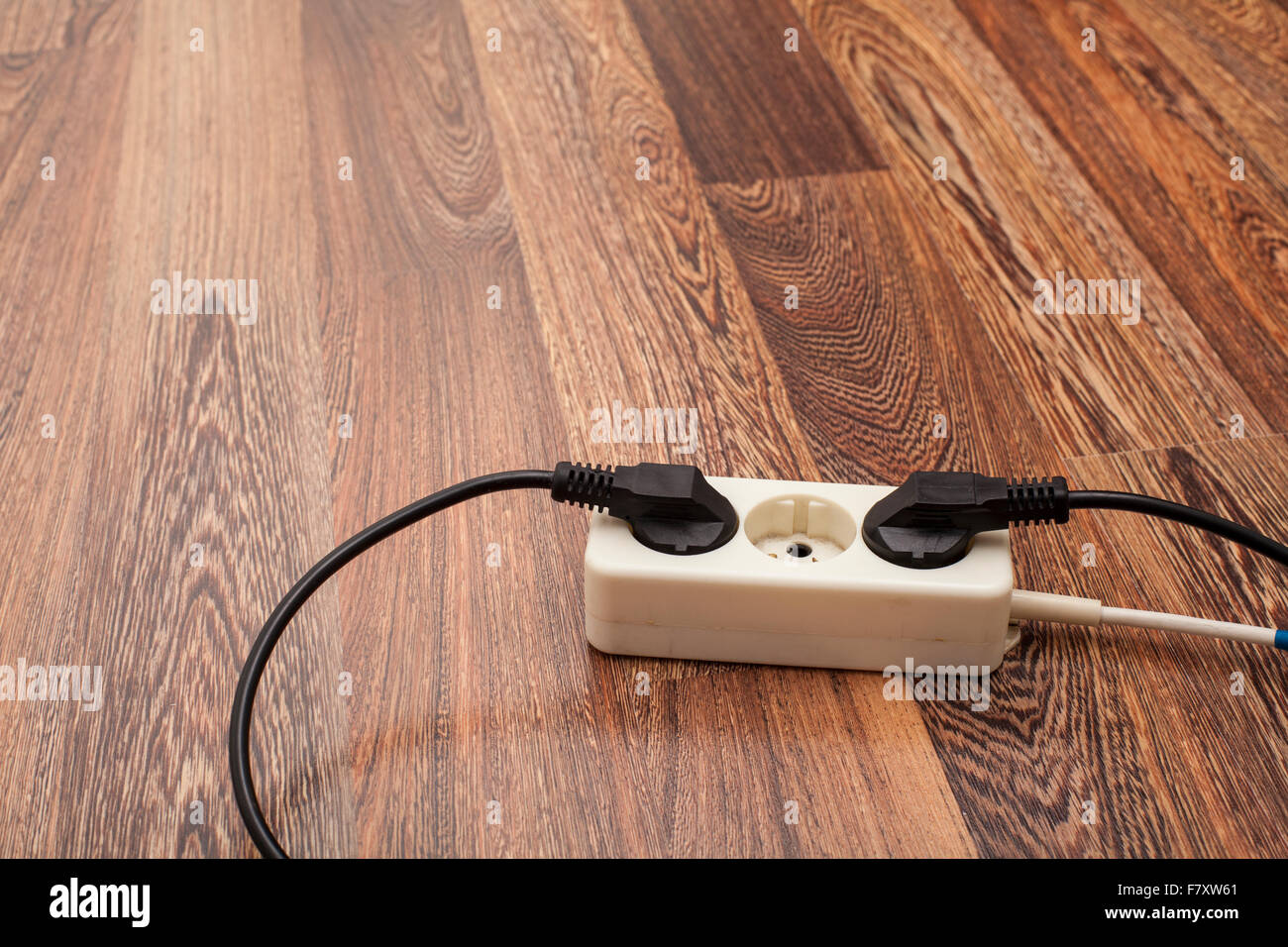 Many plugs plugged into electric power bars on floor Stock Photo - Alamy