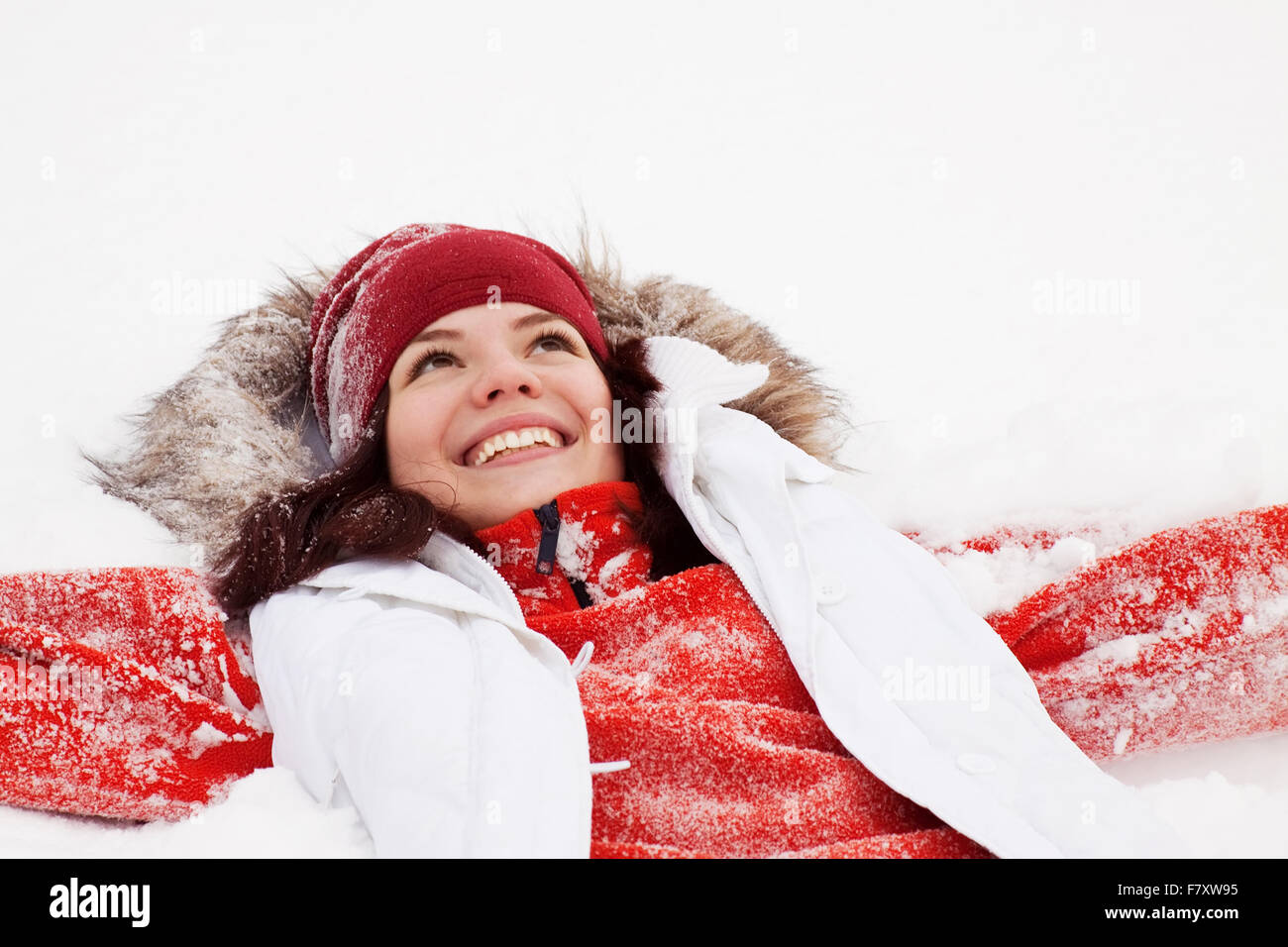 Happy girl lying down on the snow in winter Stock Photo - Alamy