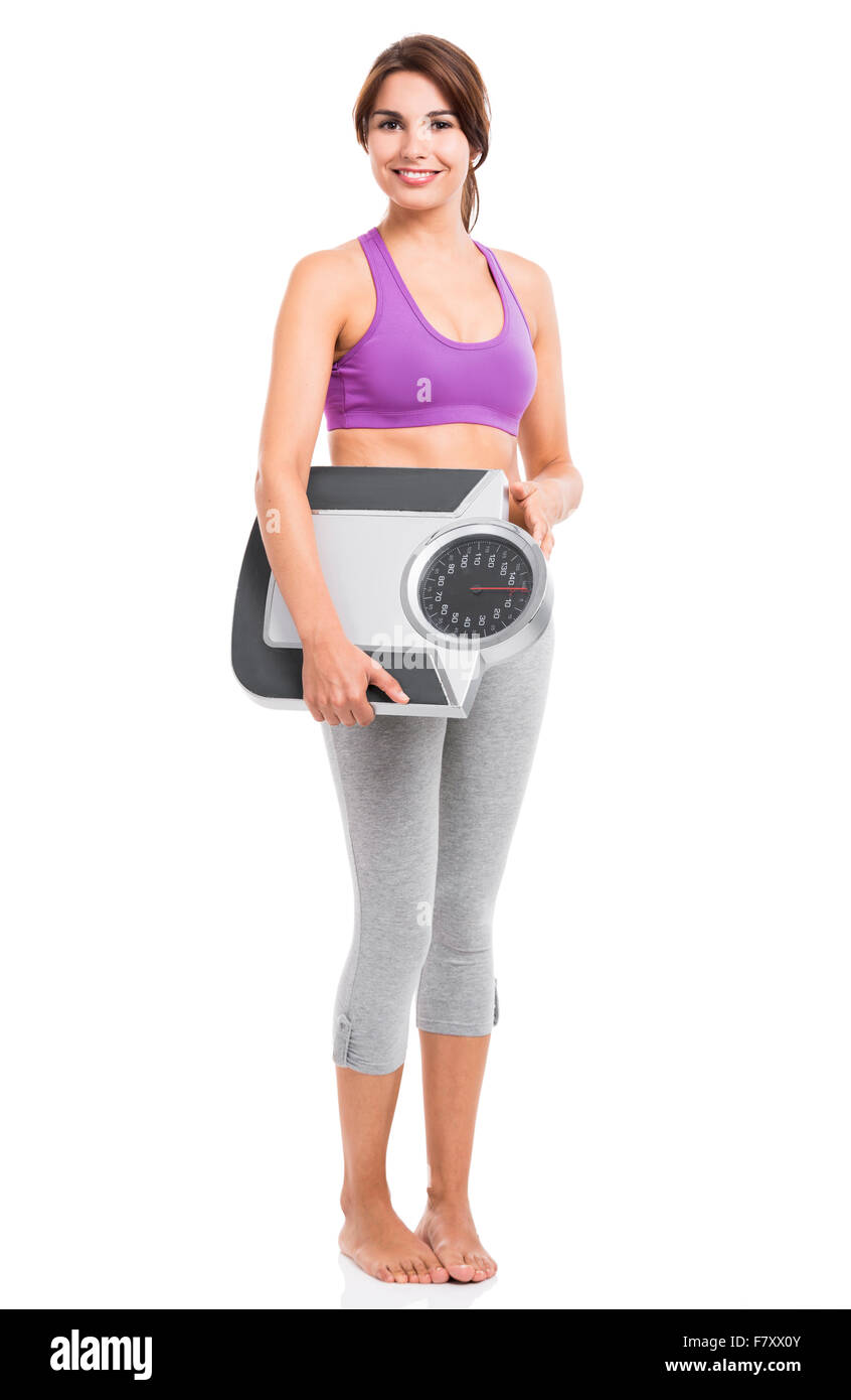 Beautiful athletic woman smilling and holding a scale, isolated on ...