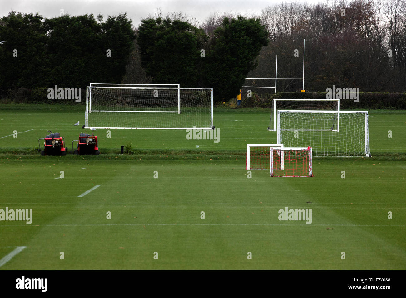 Goal posts for a variety of sports and two mowing machines on a college ...