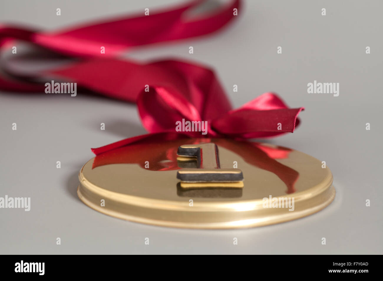 Champion Gold Medal with red ribbon on gray background Stock Photo - Alamy