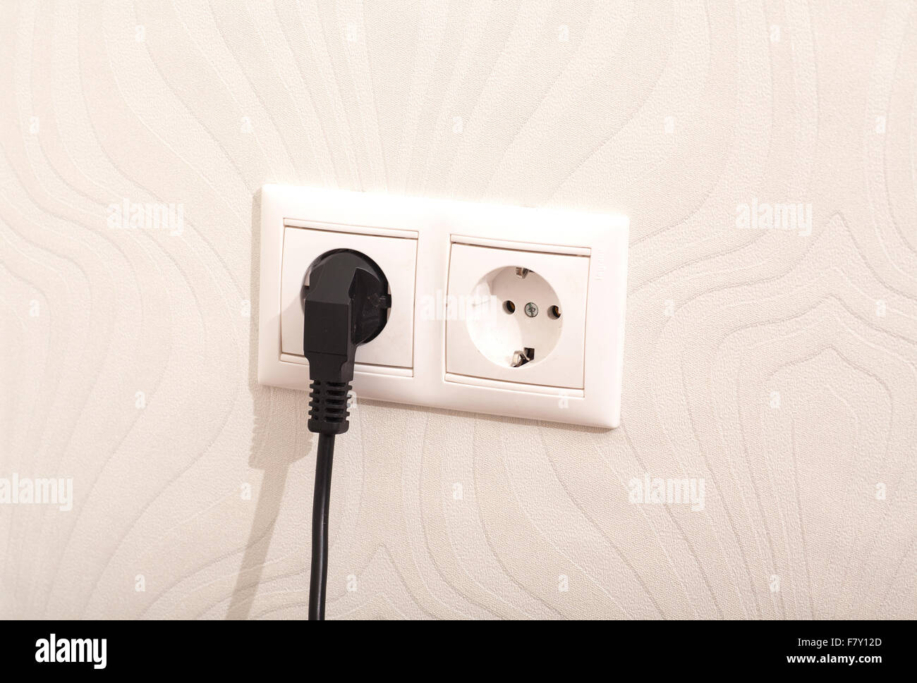 White electric socket with plug on the wall Stock Photo - Alamy
