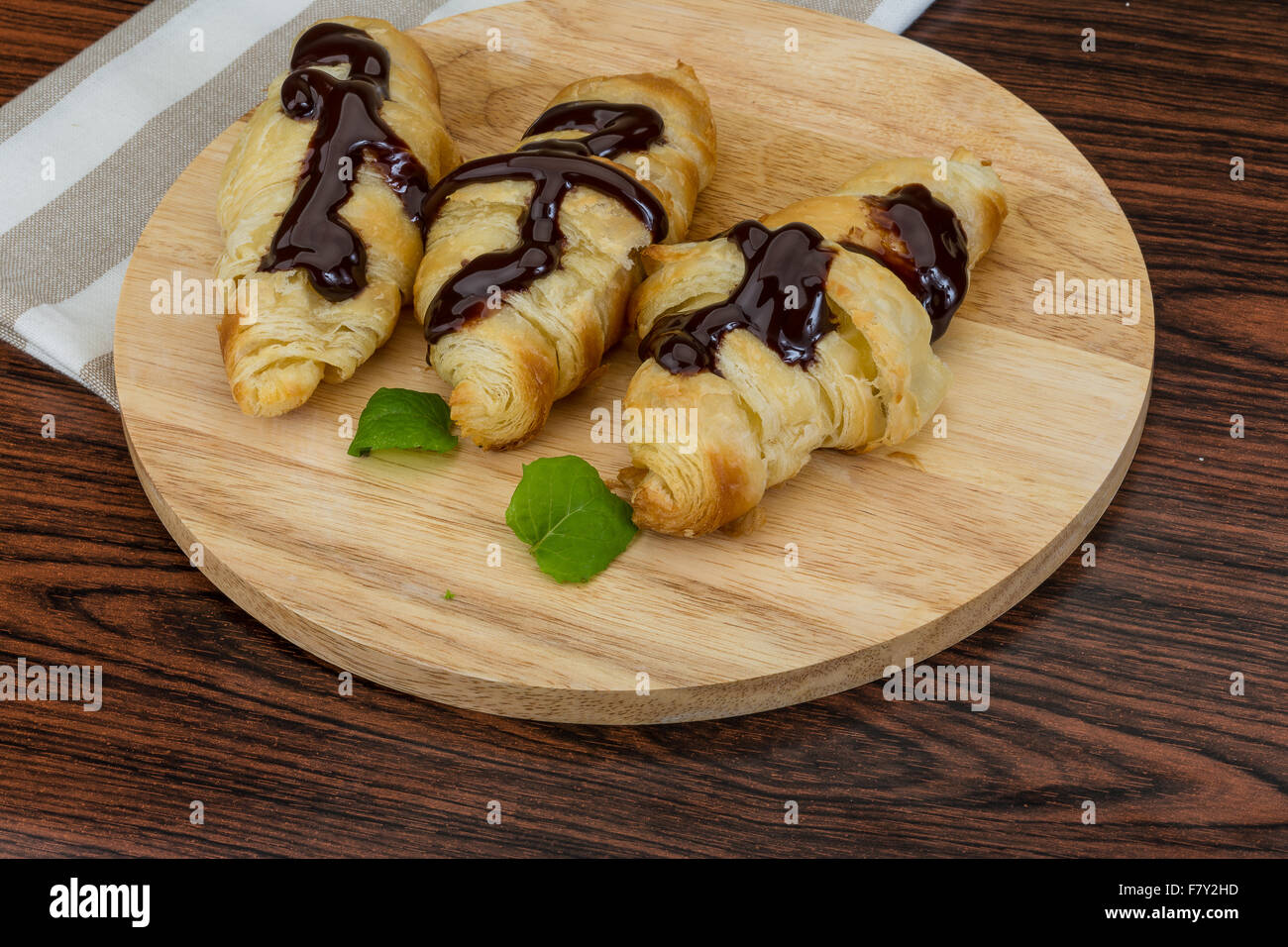 Croissant with chocolate and mint leaves on the wood background Stock ...