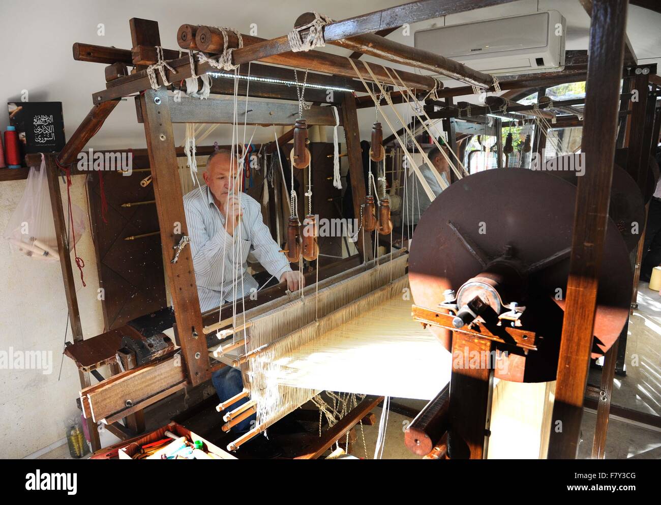 Damascus, Syria. 3rd Dec, 2015. Abu Saed, 70, works with his loom to ...