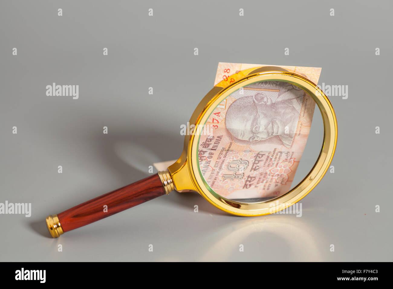 Indian Currency Rupee Notes with magnifying glass on gray Stock Photo ...