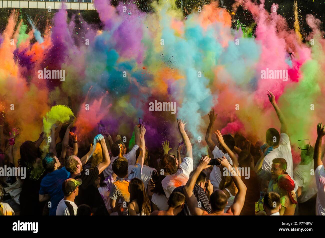 Thousands of people throw colored powder into the air during the Holi ...