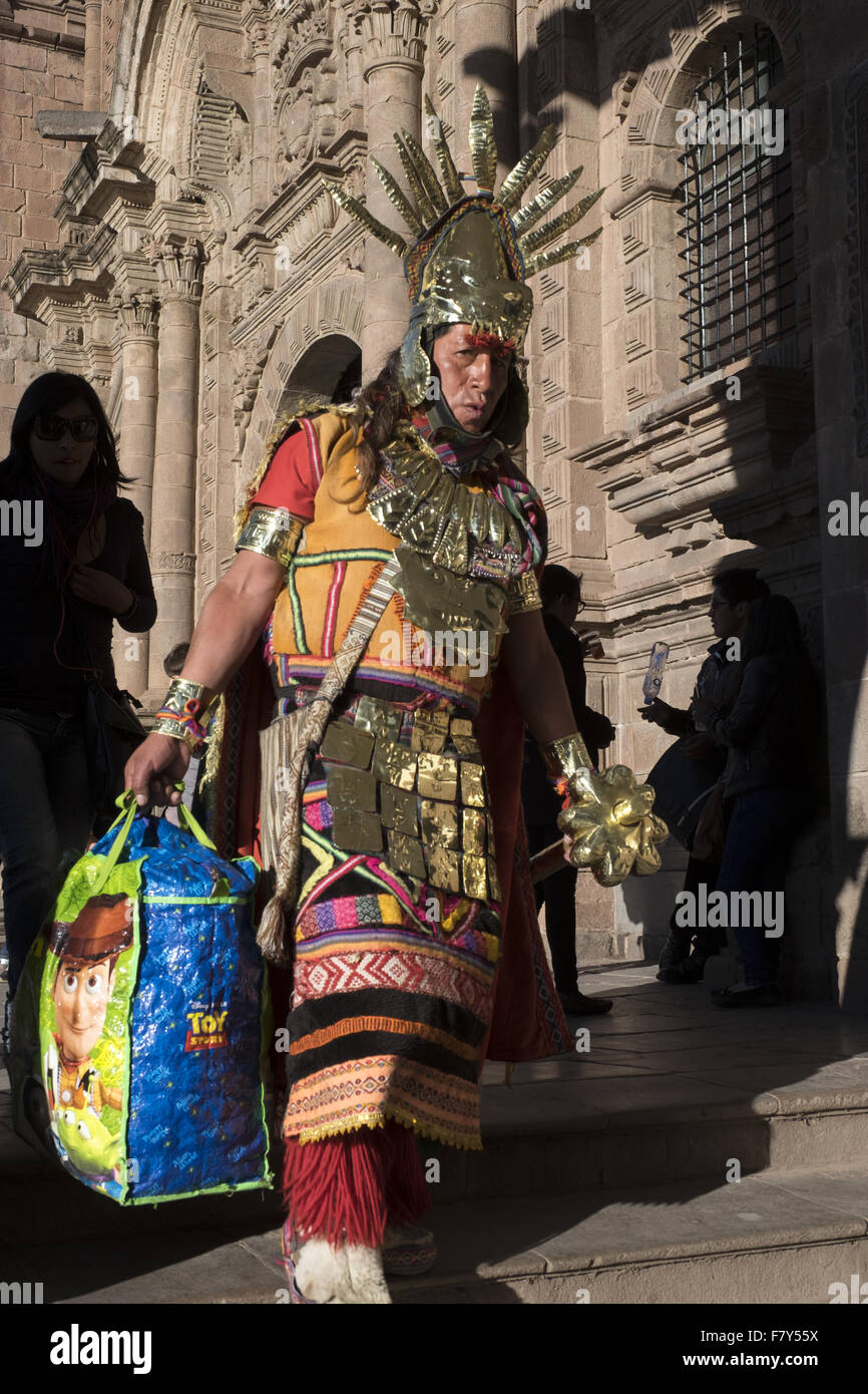A man dressed in clothes Inca walks in front of the facade of the ...