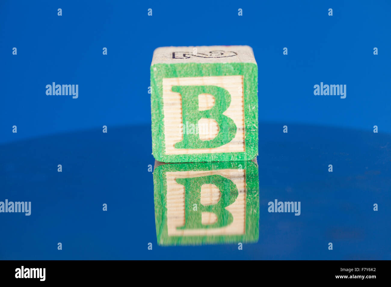 Wooden letter block B on blue background Stock Photo - Alamy