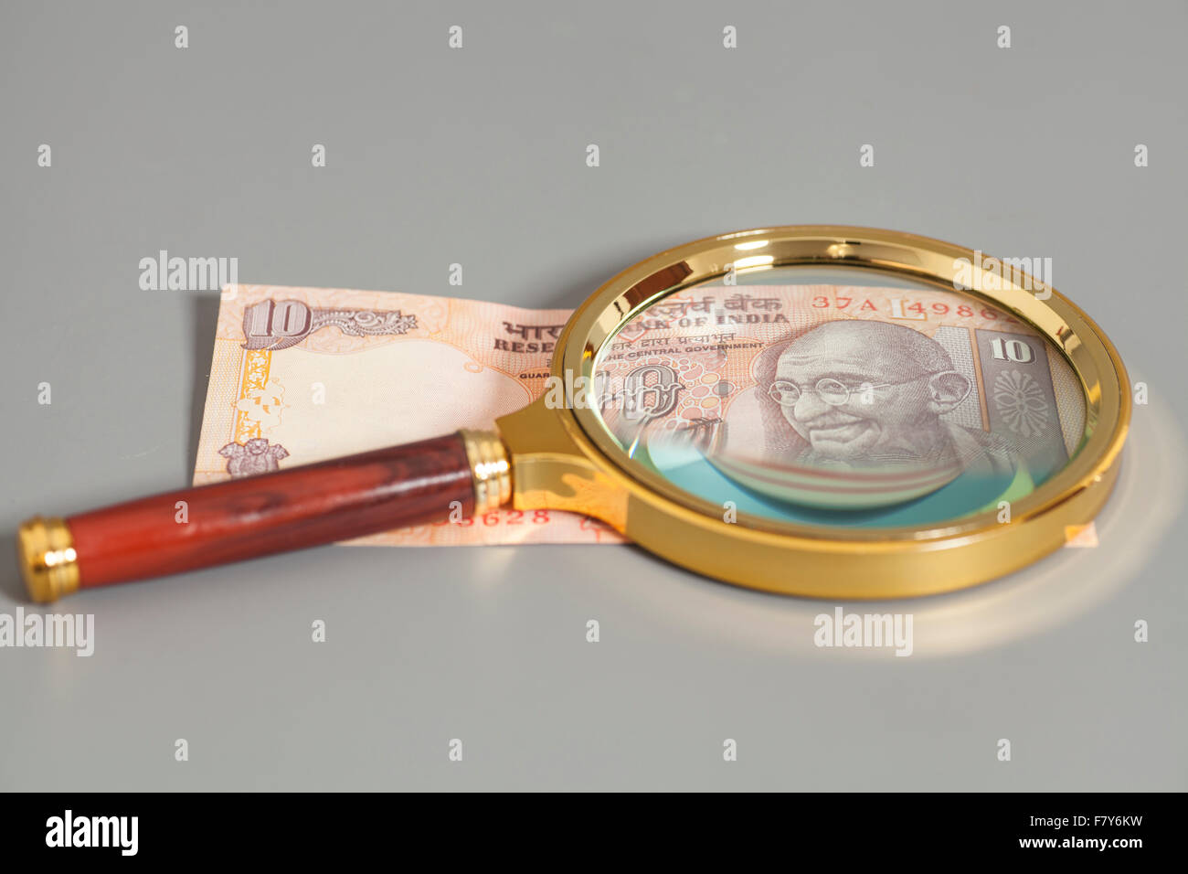 Indian Currency Rupee Notes with magnifying glass on gray Stock Photo ...