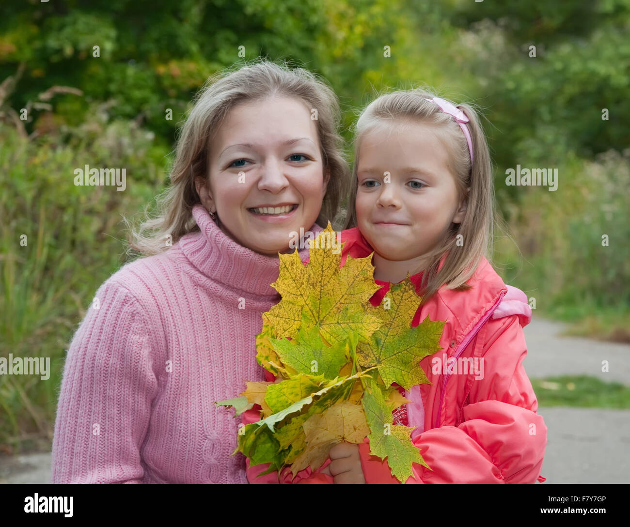 Happy mother with her daughter against fall Stock Photo - Alamy