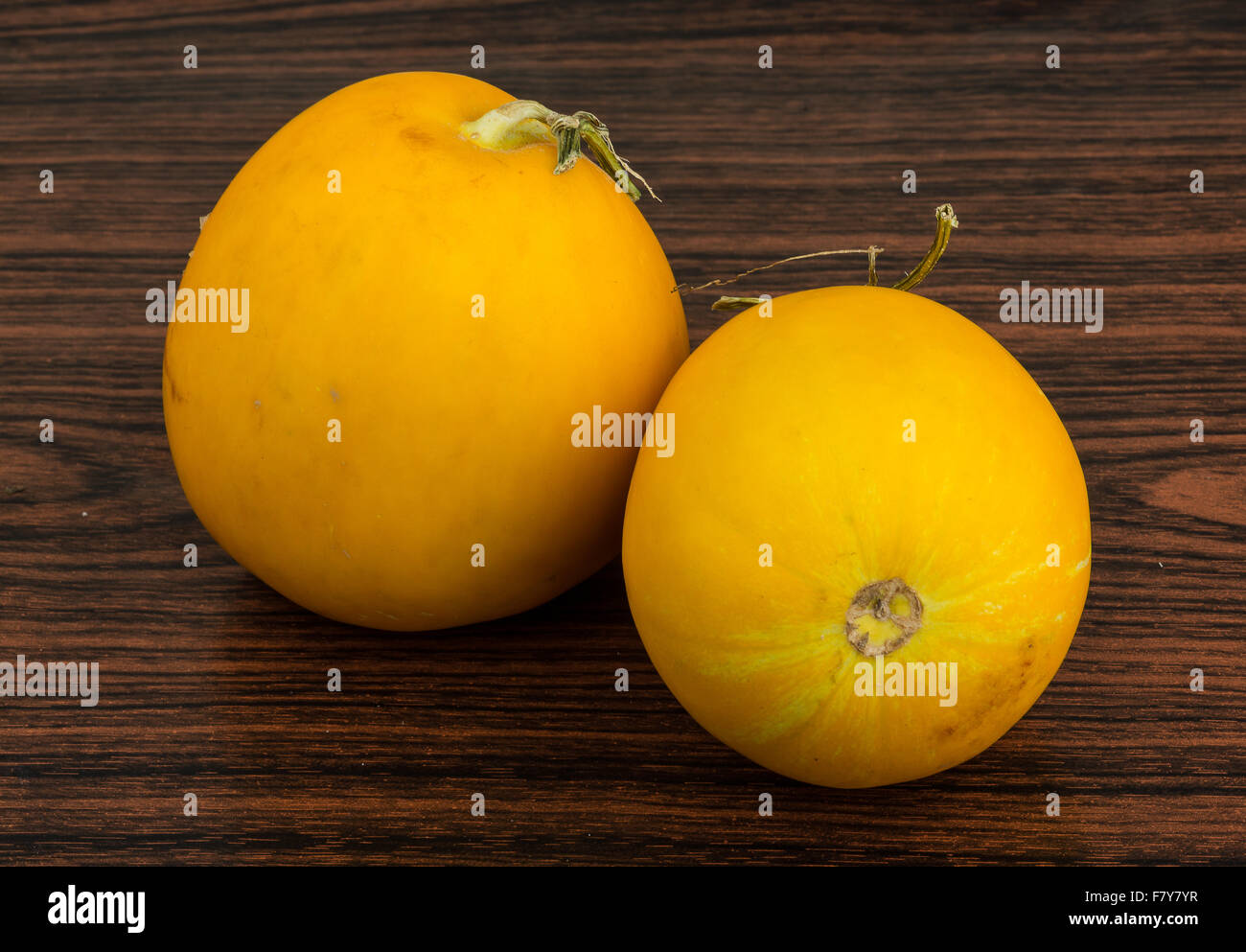 Small yellow melon on the wooden background Stock Photo - Alamy