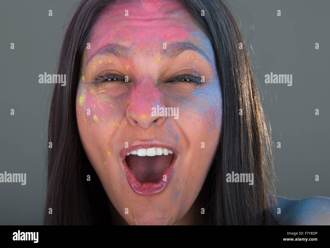 Beautiful young brunette girl with colorful decorated face celebrating ...