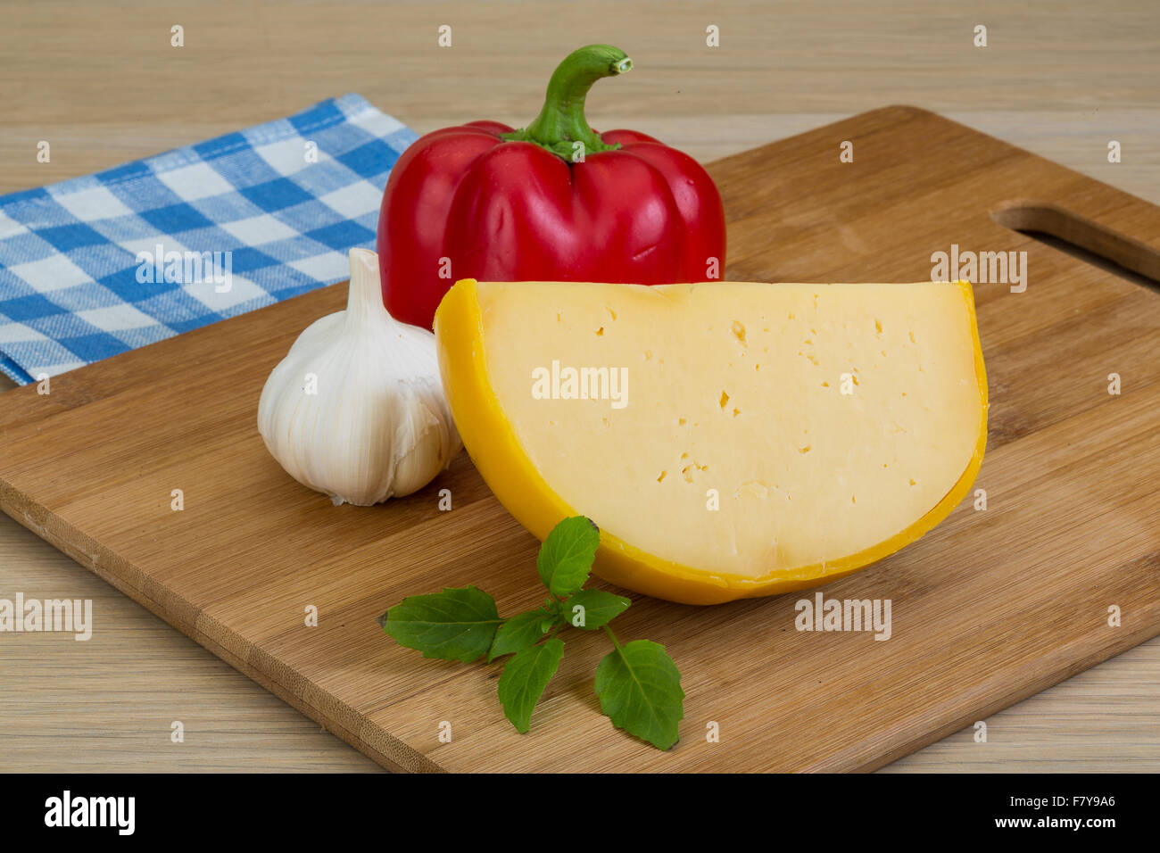 Yellow round cheese on the wood background Stock Photo - Alamy