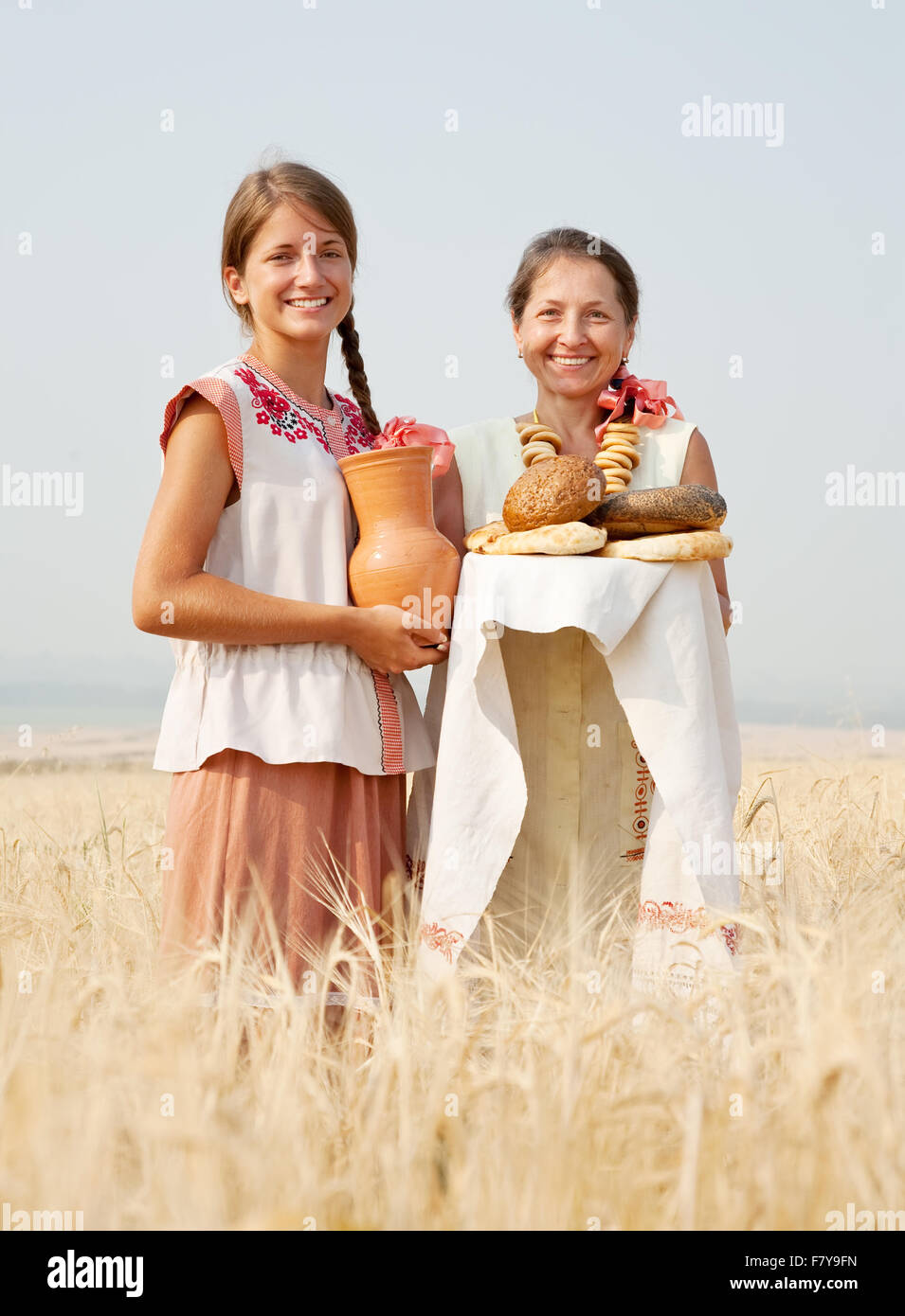Women in traditional clothes with bread at cereals field Stock Photo ...