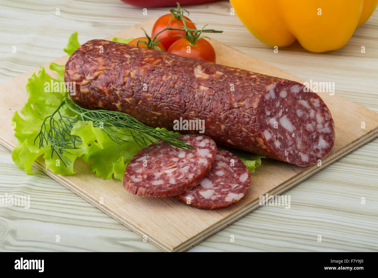Sliced Salami with salad leaves on the wood background Stock Photo - Alamy