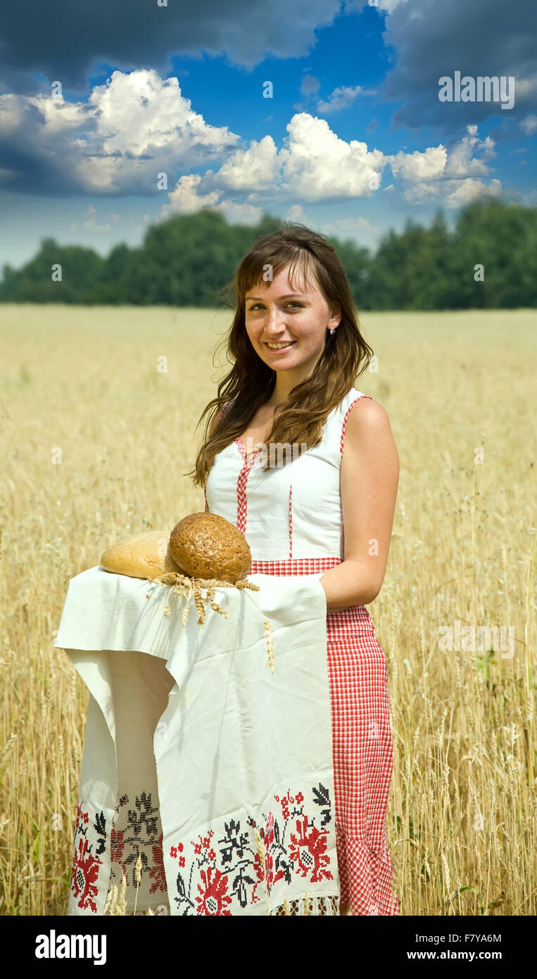 Girl in traditional clothes with bread at wheat field Stock Photo - Alamy