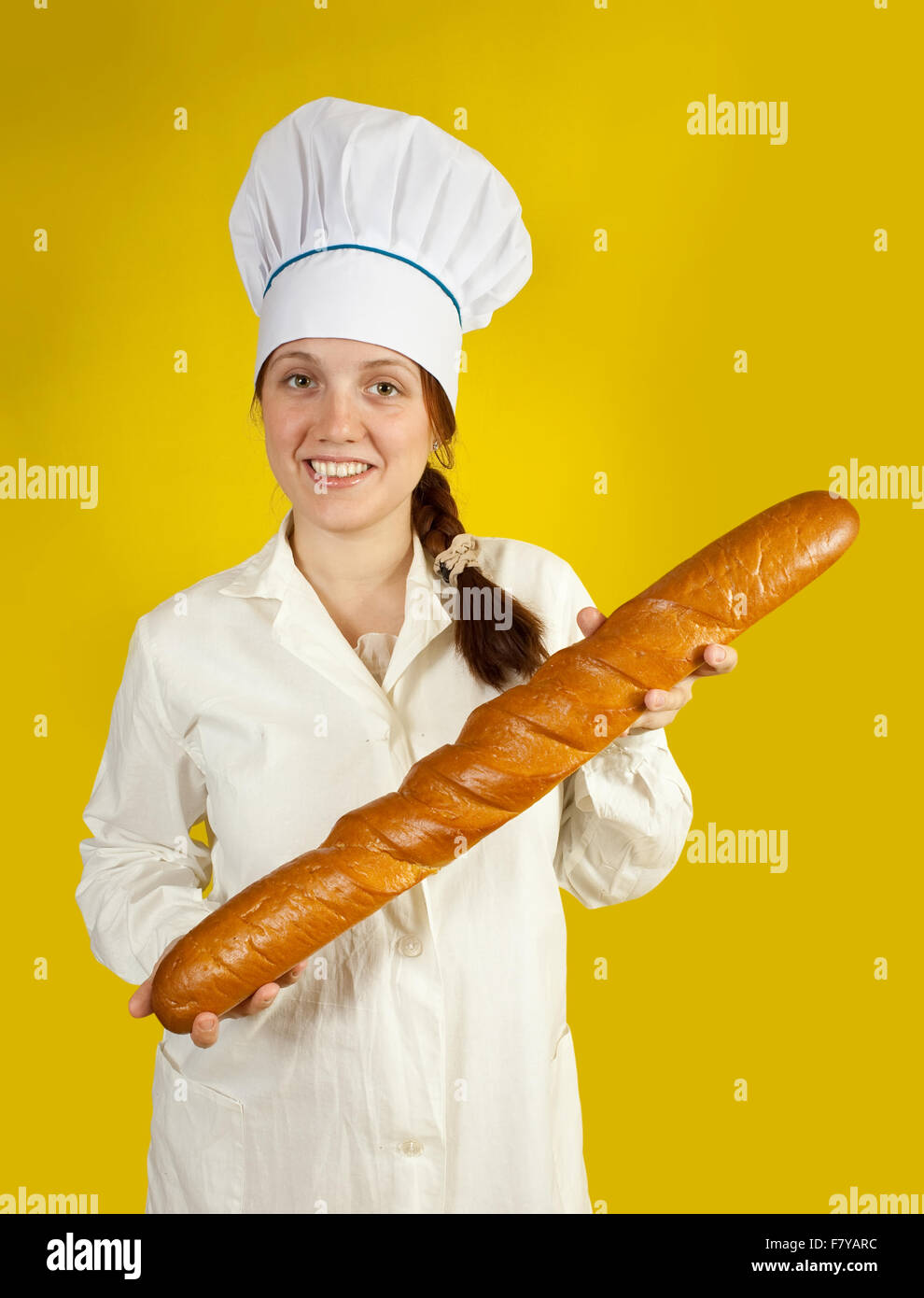 female baker with French long baton over yellow Stock Photo - Alamy