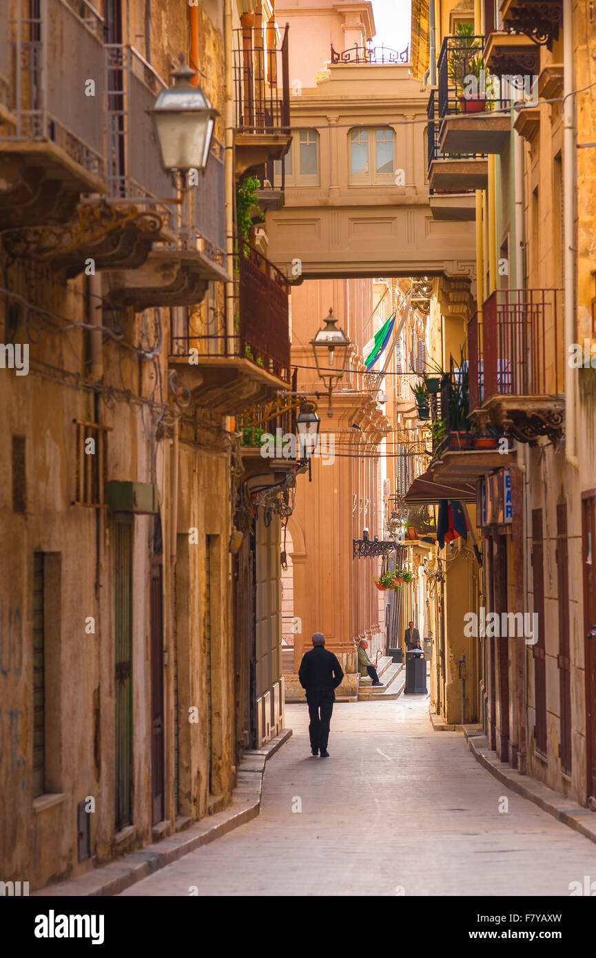 Sicily street, view in summer of a man walking along the Via Mario ...