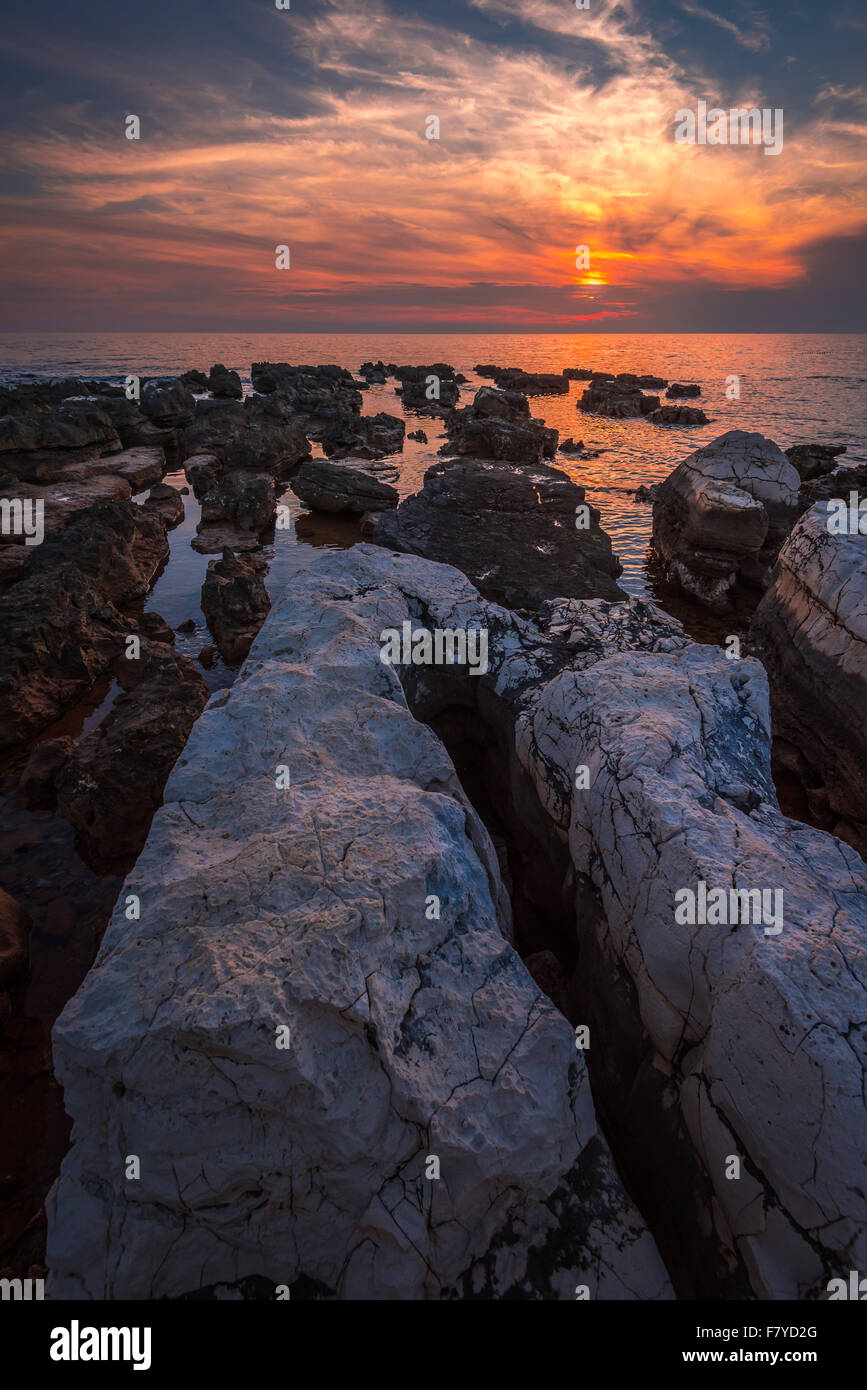 Sunset Over the Sea with Rocks in Foreground Stock Photo - Alamy