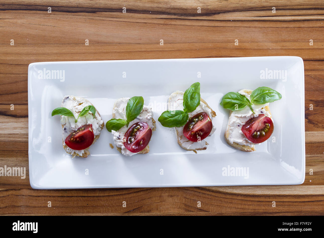 small bite size appetizer with goat cheese and tomato on a piece of ...