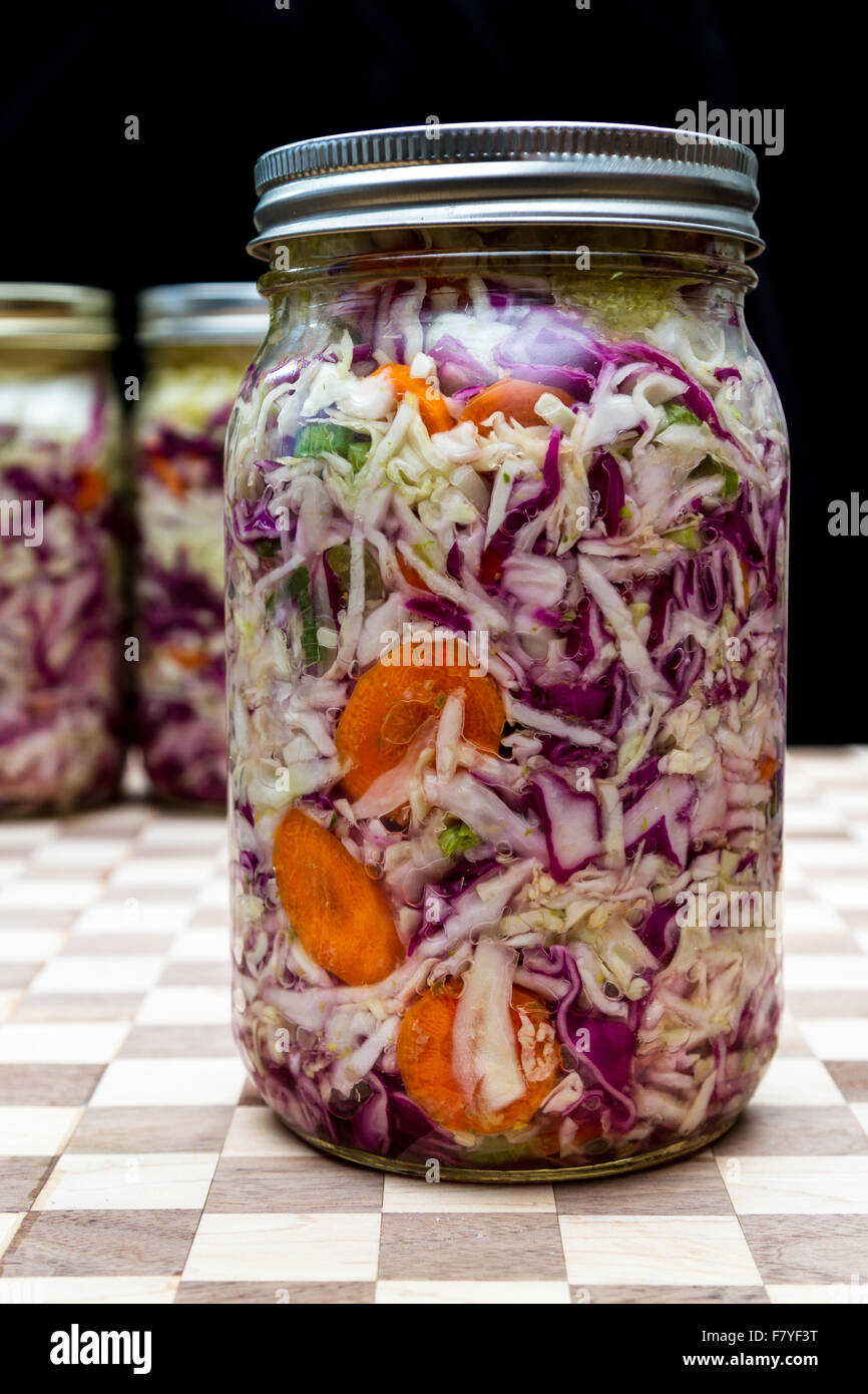 home made cultured or fermented vegetables in a jar over a dark ...
