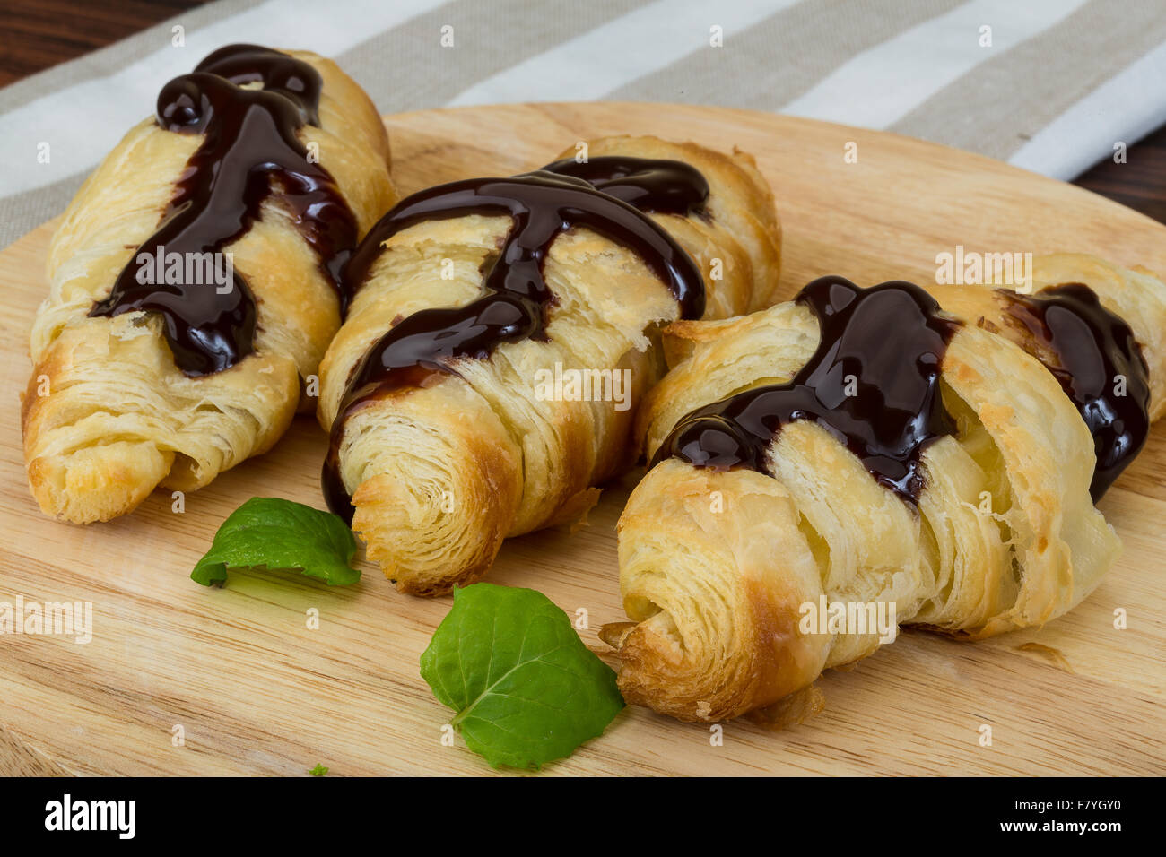 Croissant with chocolate and mint leaves on the wood background Stock ...