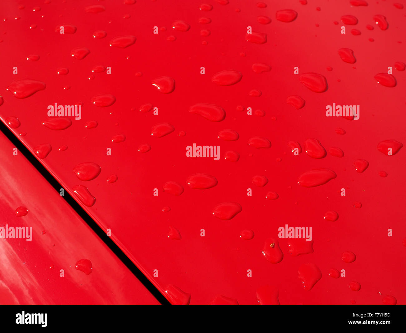raindrops on bright red bonnet of classic car with gleaming paintwork ...